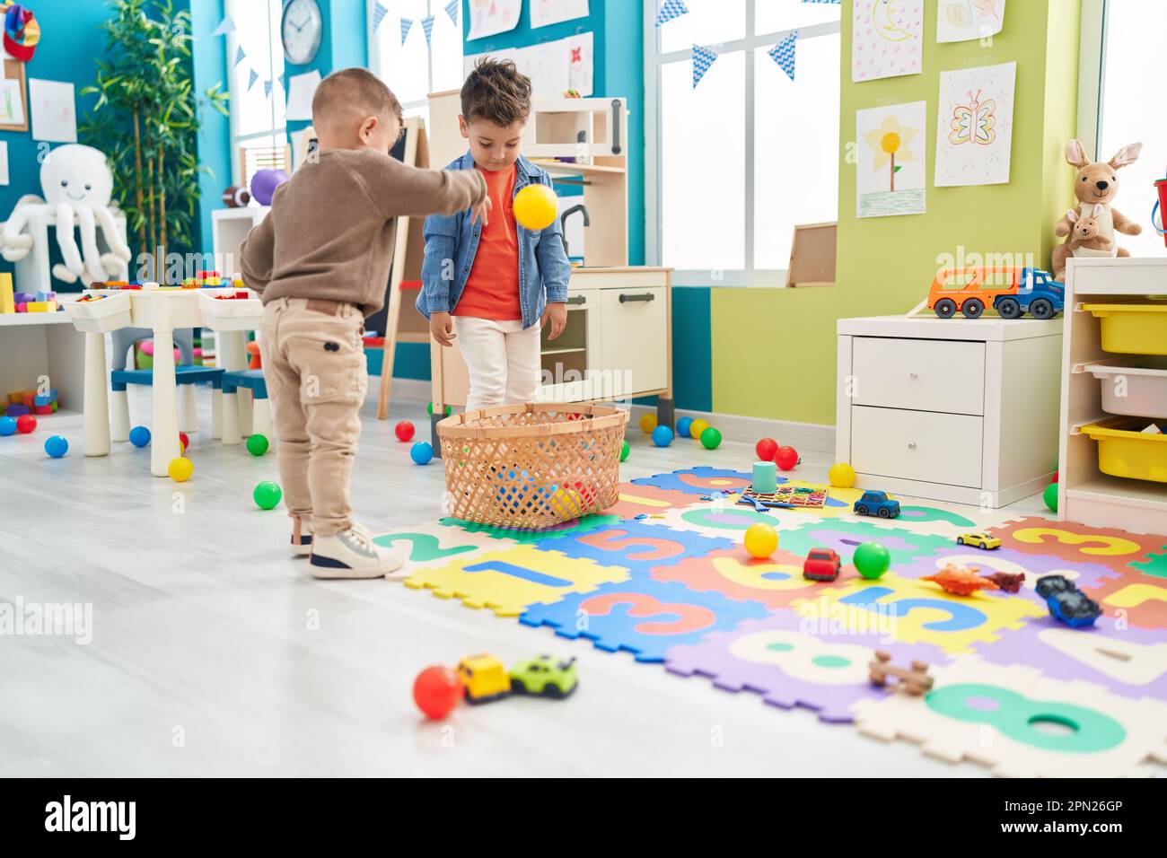 Adorable boys playing with balls standing at kindergarten Stock Photo ...