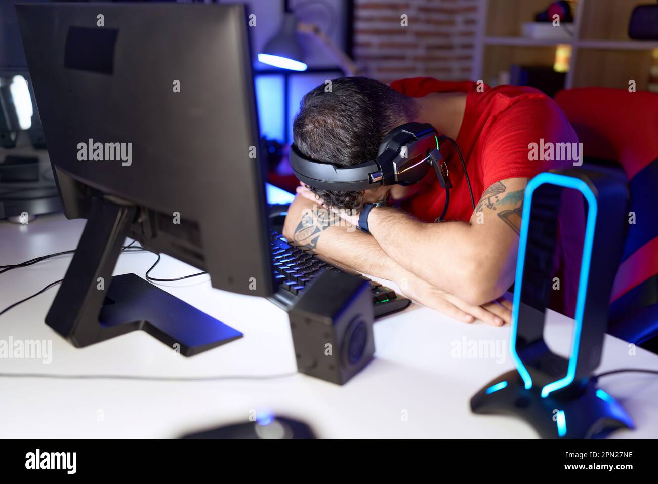 Young hispanic man streamer stressed using computer at gaming room ...