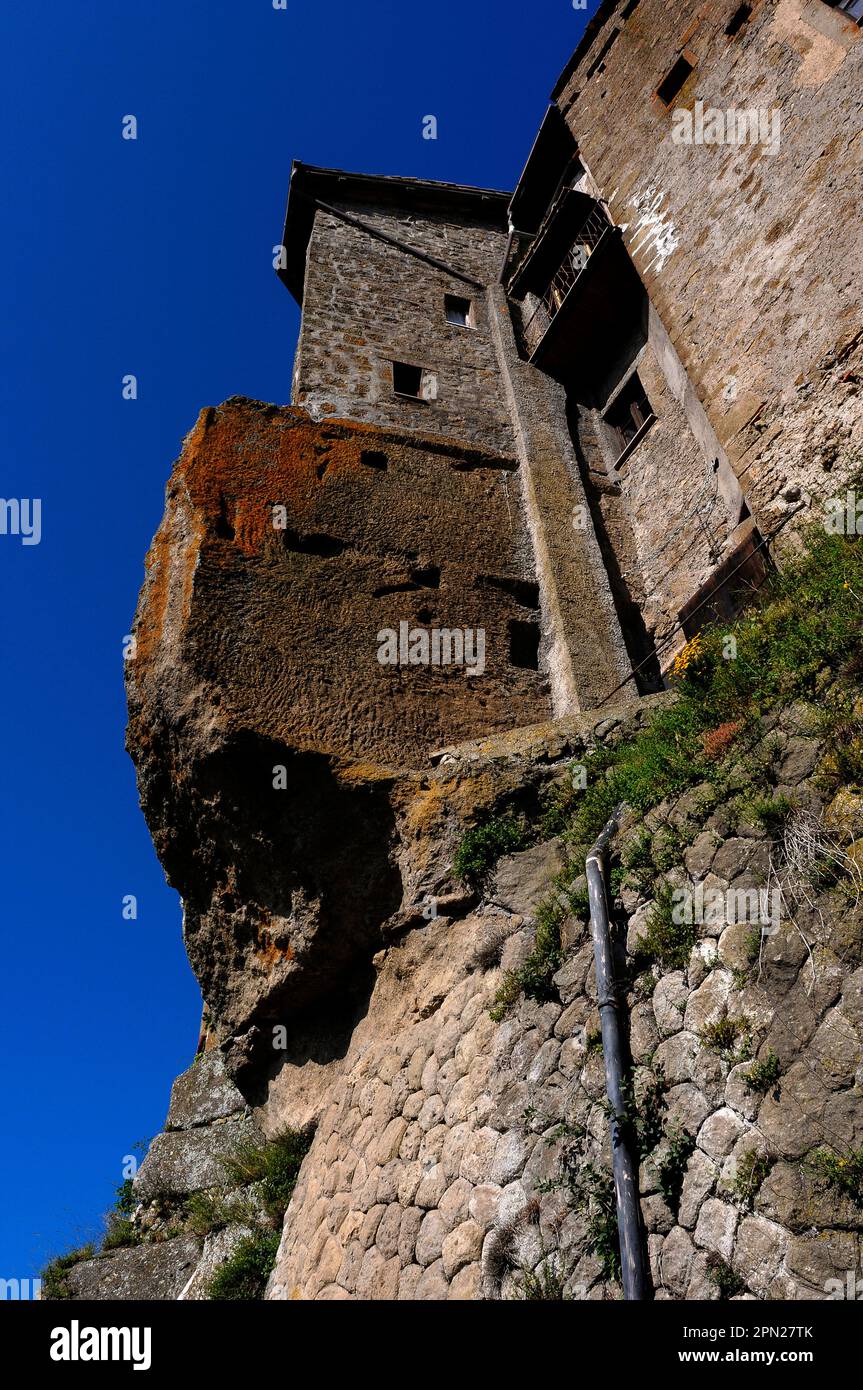 Traditional stone rubble homes perched on an outcrop of volcanic rock ...