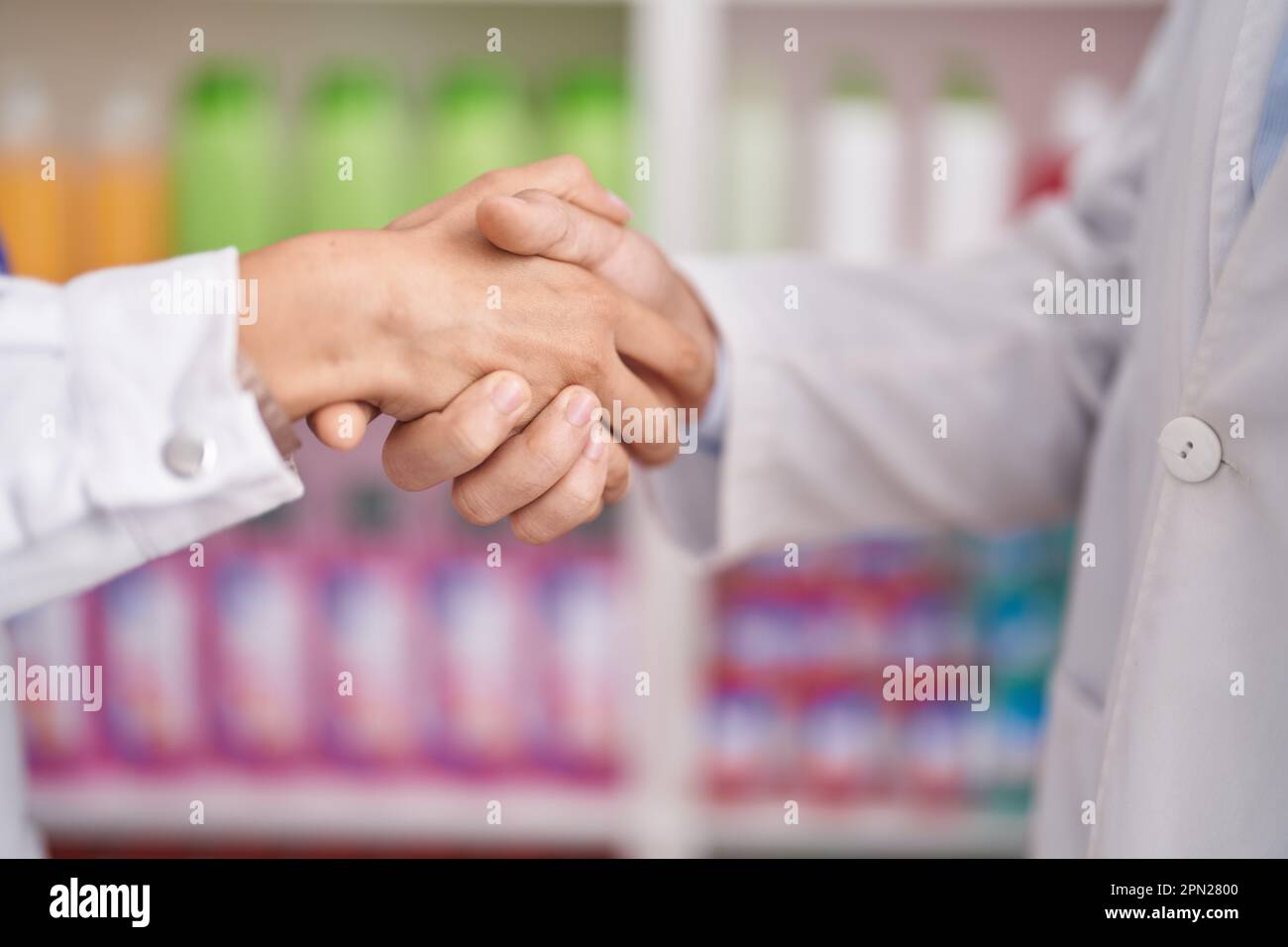 Man and woman pharmacists shake hands at pharmacy Stock Photo - Alamy