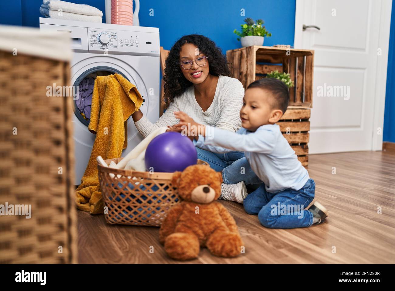 Mother and son smiling confident washing clothes at laundry room Stock ...