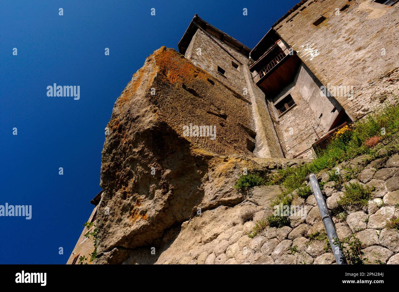 Projecting block of volcanic rock supports traditional stone rubble ...