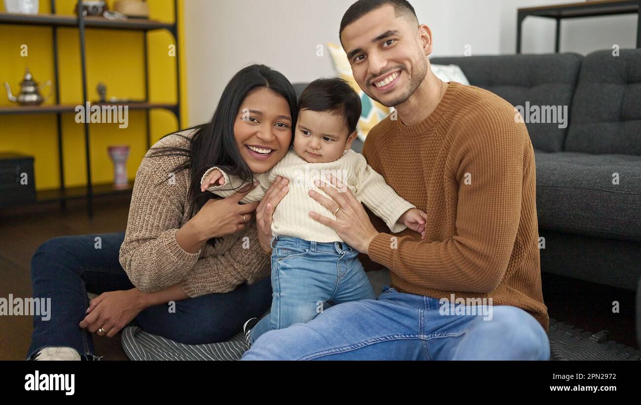 Couple and son hugging each other sitting on floor at home Stock Photo ...