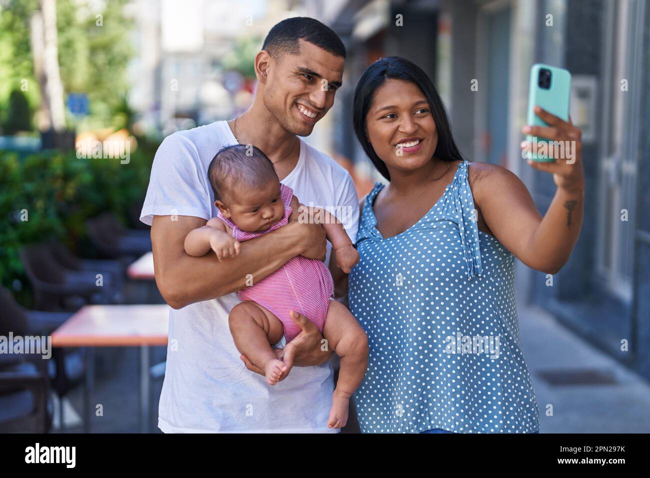 Hispanic family hugging each other making selfie by smartphone at ...
