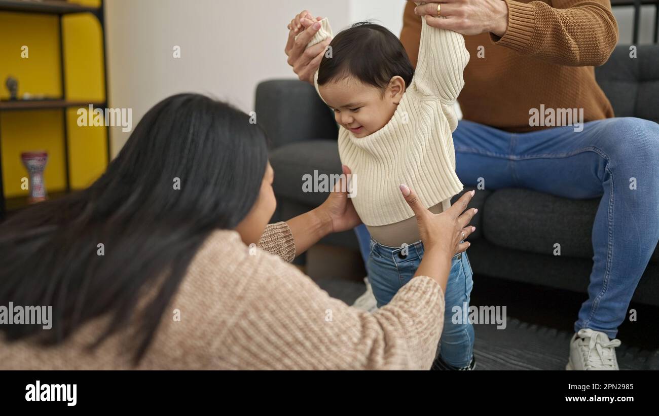 Couple and son sitting on floor together walking at home Stock Photo ...