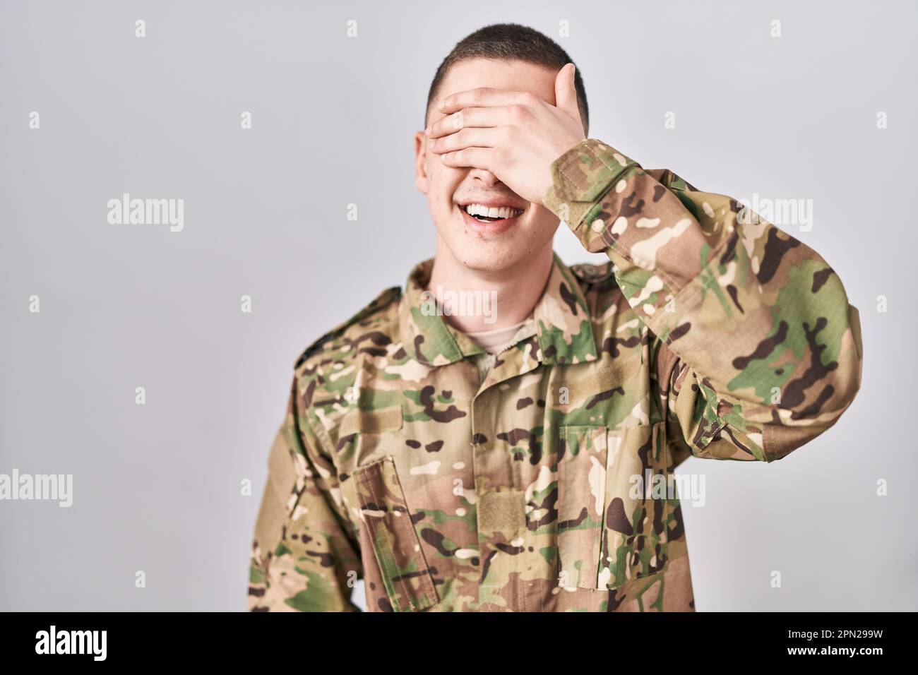 Young man wearing camouflage army uniform smiling and laughing with ...