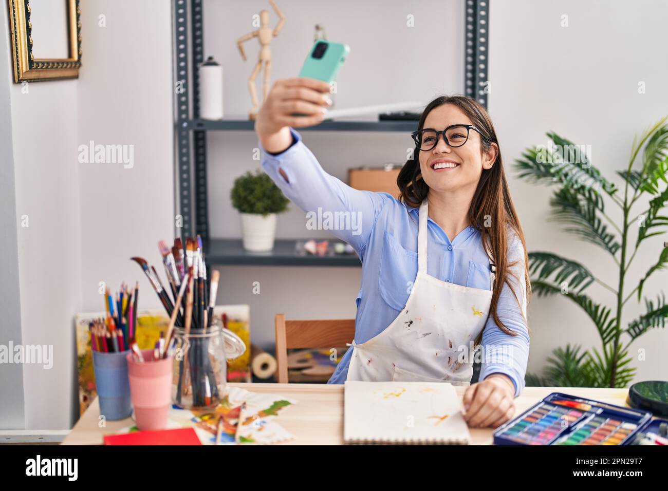 Young woman artist make selfie by the smartphone drawing on notebook at ...