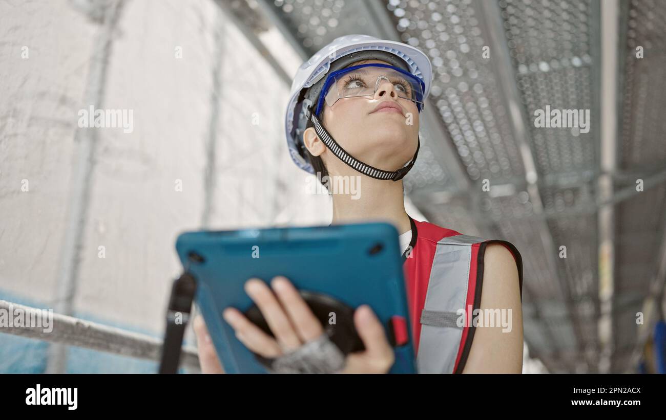 Young beautiful hispanic woman builder using touchpad at street Stock ...