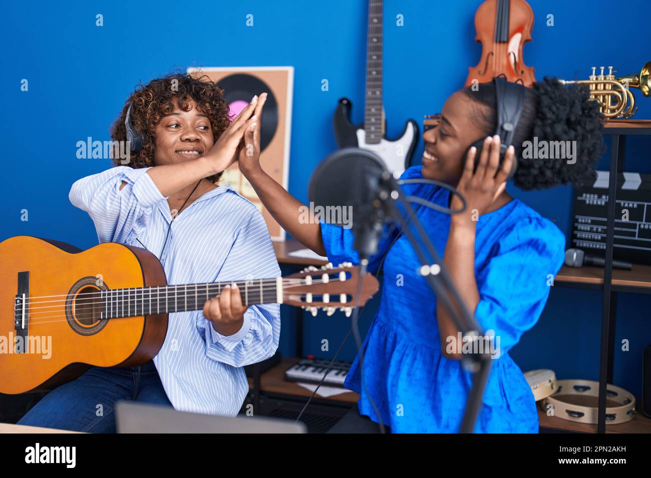 African american women musicians high five with hands raised up at ...