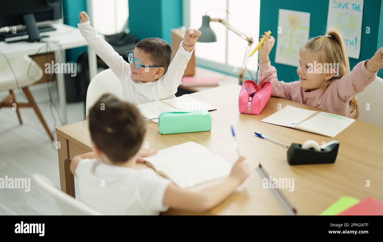 Group of kids students sitting on table with winner expression at ...