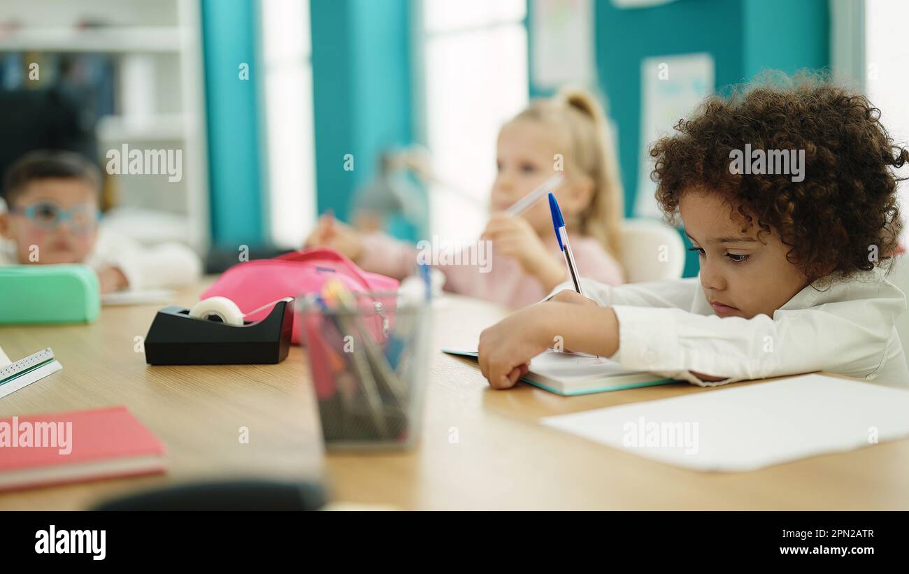 Group of kids students sitting on table studying at classroom Stock ...