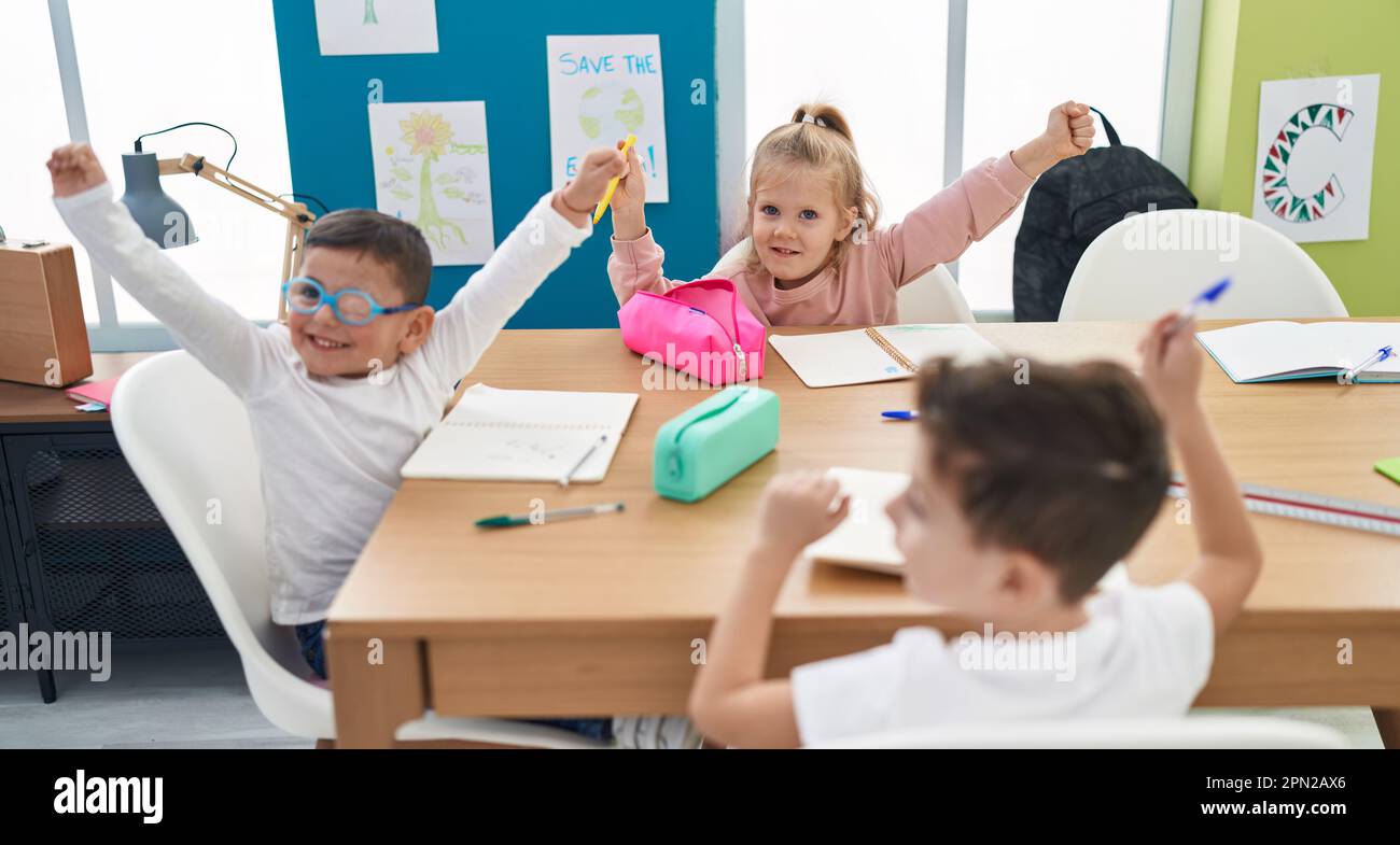 Group of kids students sitting on table with winner expression at ...