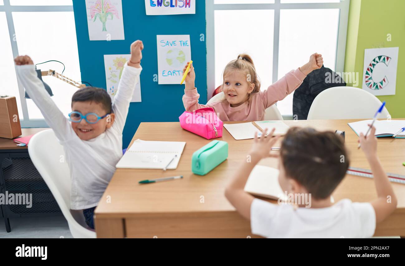 Group of kids students sitting on table with winner expression at ...