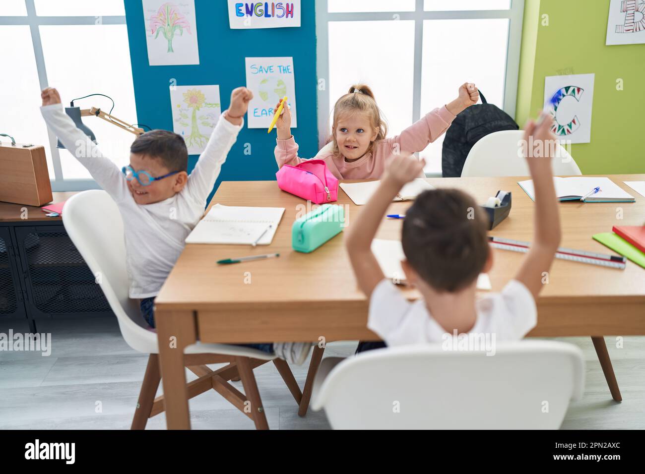 Group of kids students sitting on table with winner expression at ...