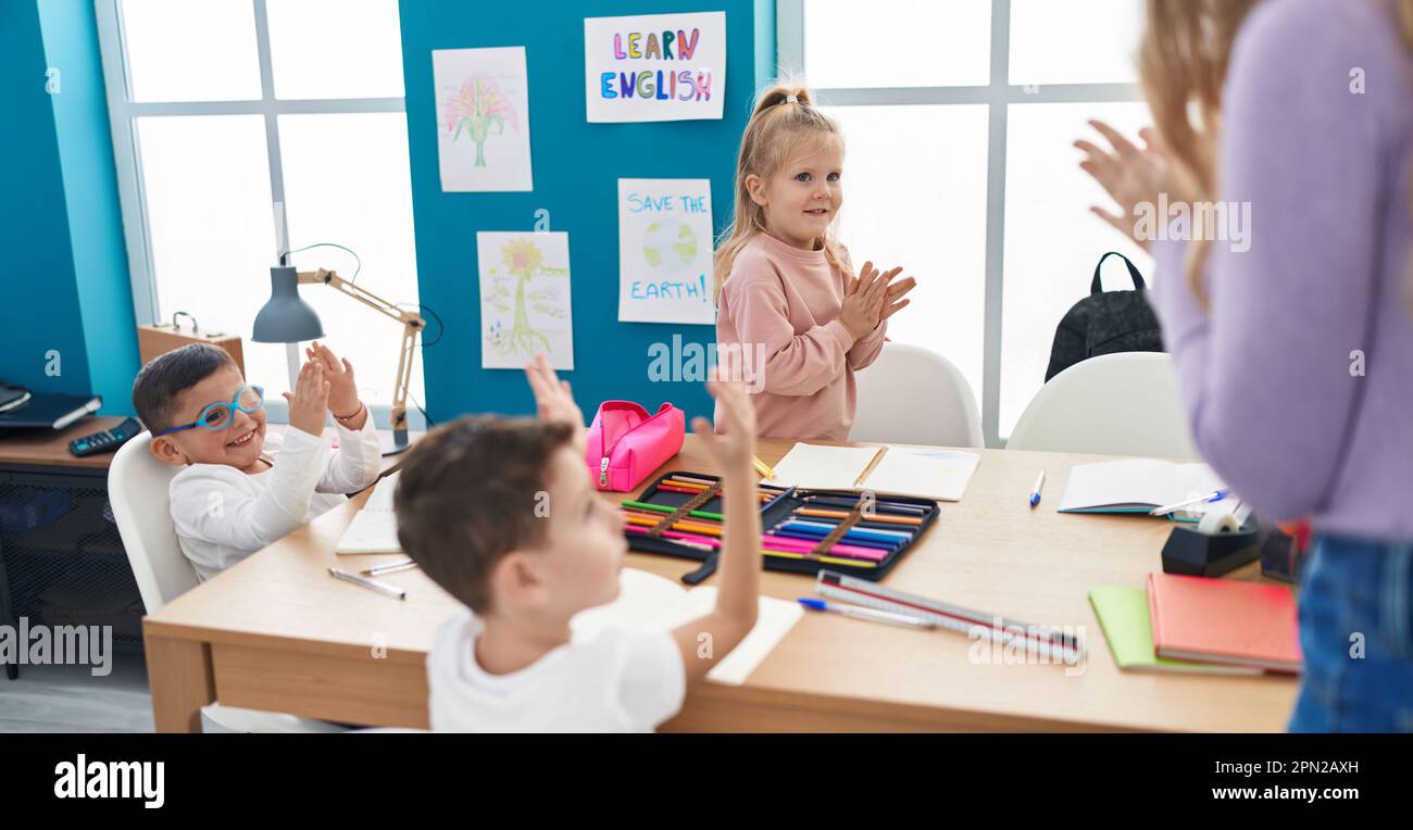 Group of kids students sitting on table clapping hands at classroom ...