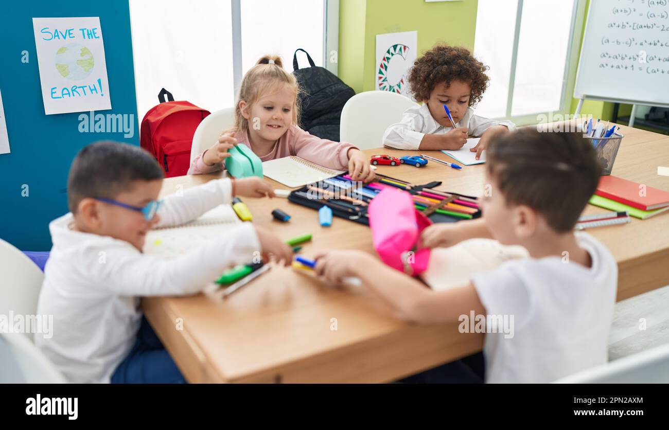 Group of kids students sitting on table drawing on notebook at ...