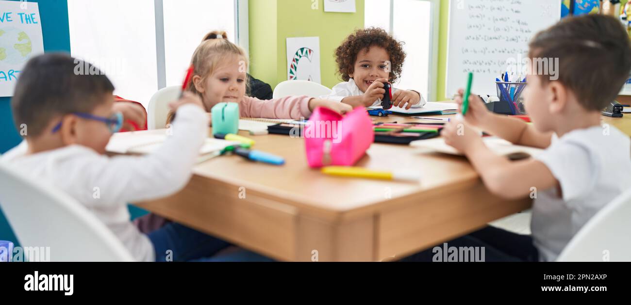 Group of kids students sitting on table drawing on notebook at ...