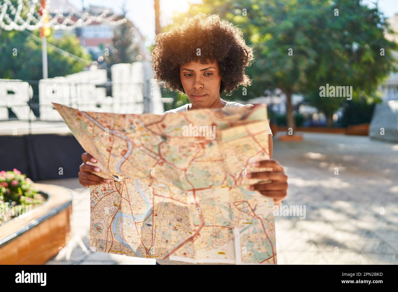 African american woman holding city map at park Stock Photo - Alamy