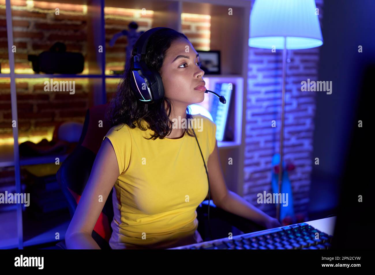 Young african american woman streamer playing video game using computer ...