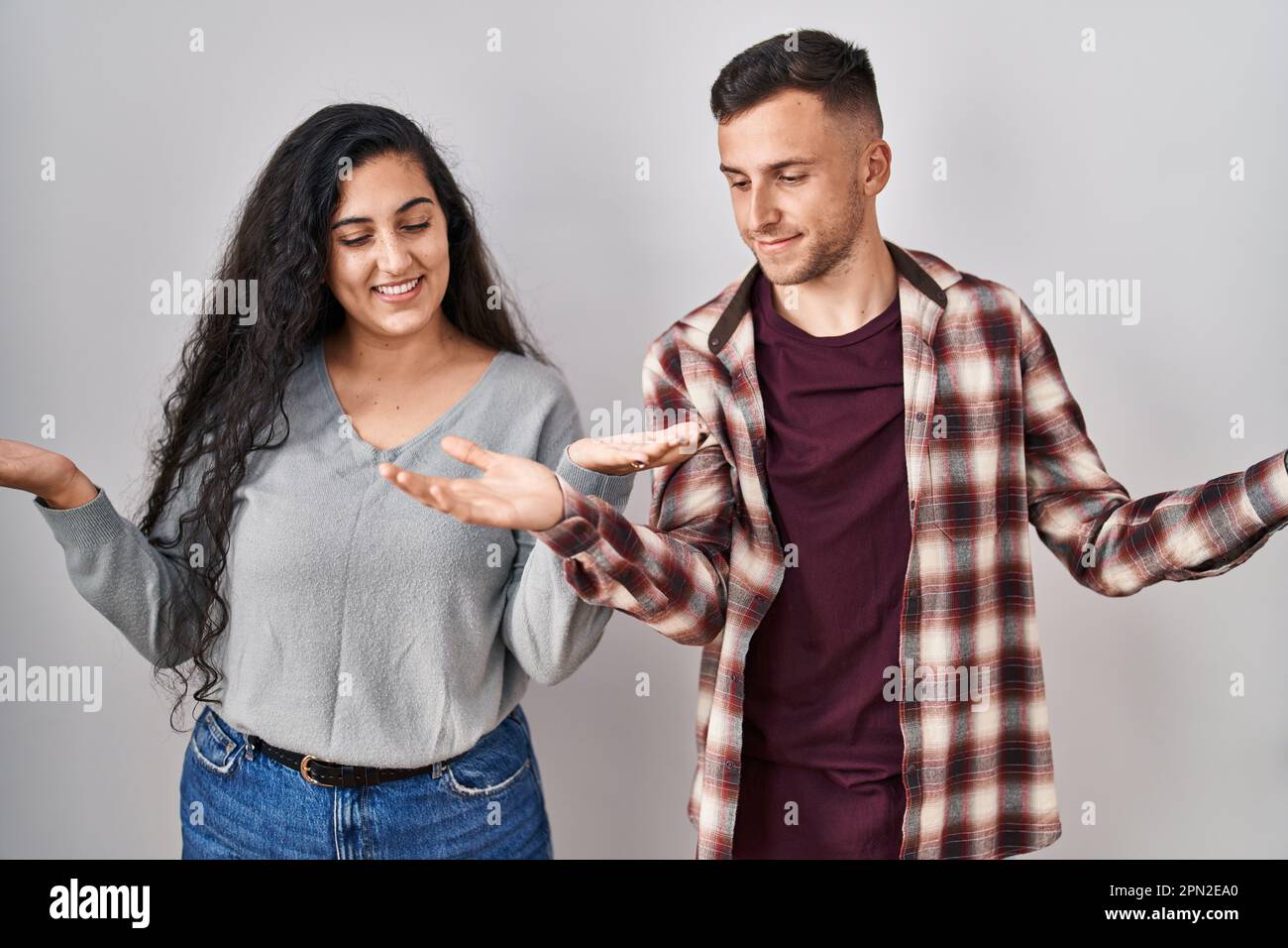 Young hispanic couple standing over white background smiling showing ...