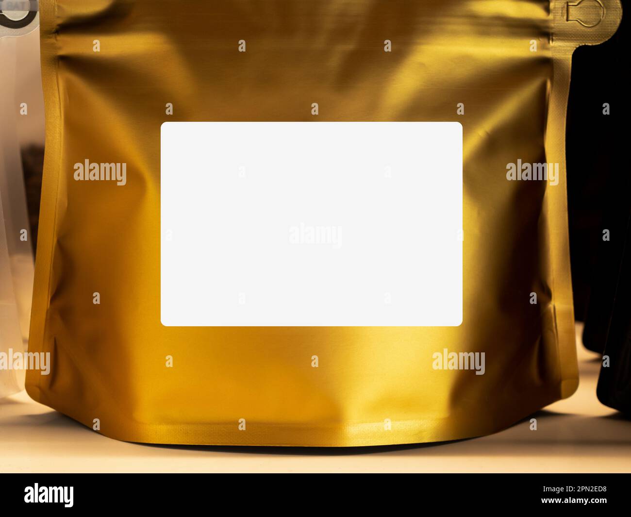 Close Up empty blank white label on modern gold foil bag coffee beans ...