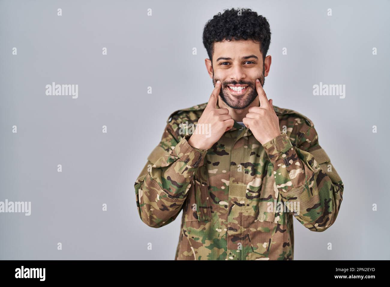 Arab man wearing camouflage army uniform smiling with open mouth ...