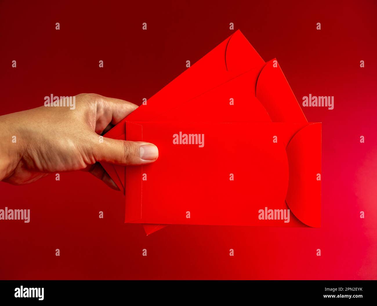 Three red envelope holding by hand isolated on red background. 3 ...