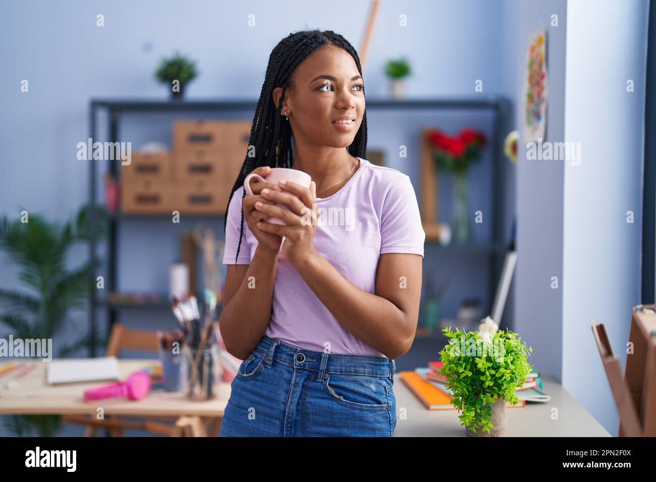 African american woman artist smiling confident drinking coffee at art ...