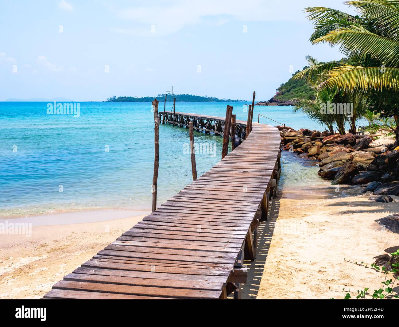 Wooden bridge heading to the blue sea. Brown wood plank pathway bridge ...