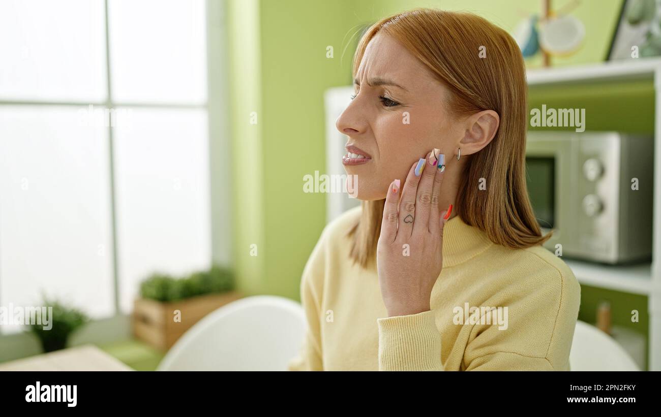Young blonde woman suffering for teeth pain at home Stock Photo - Alamy