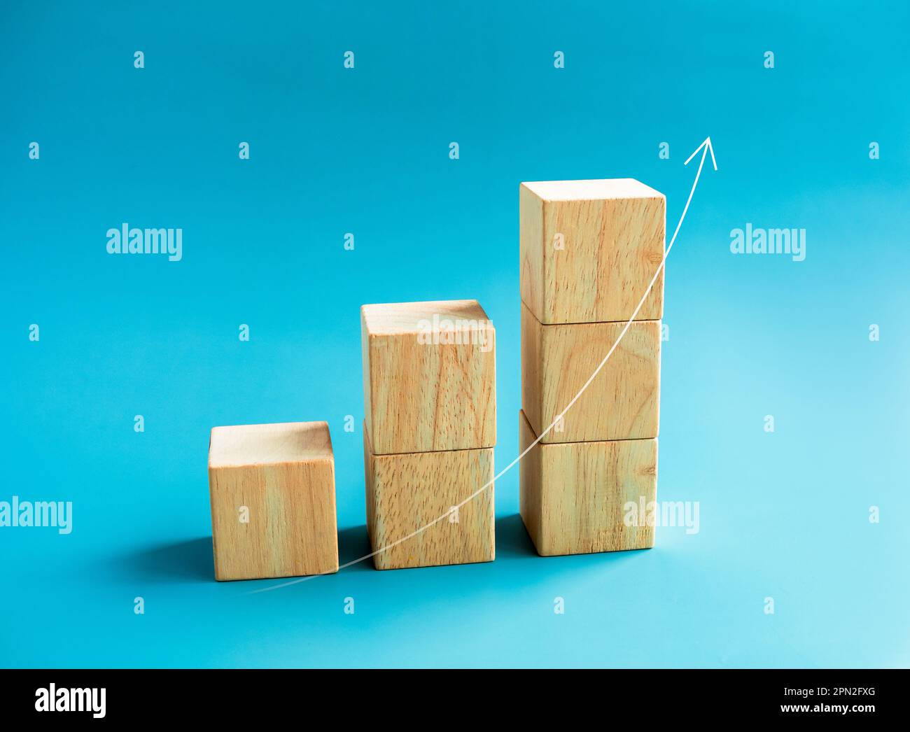 Rising up curved thin arrow draw on wooden cube blocks bar graph chart ...