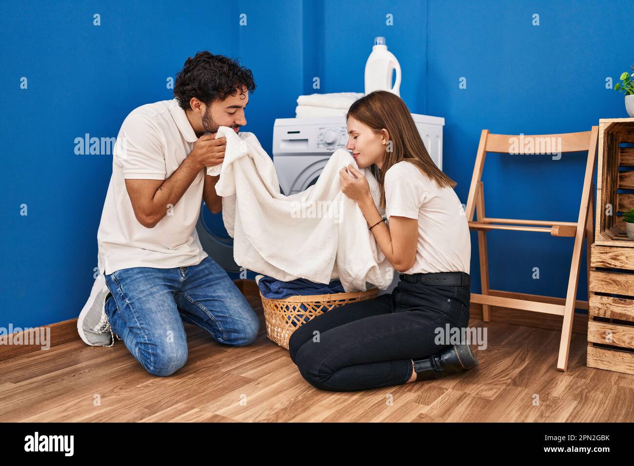 Man and woman couple smiling confident smelling towel at laundry room Stock Photo - Alamy