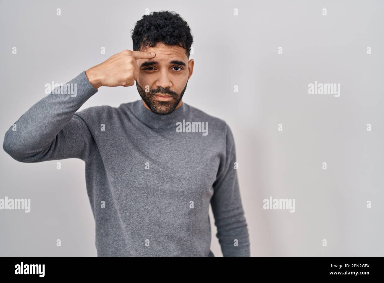Hispanic man with beard standing over white background pointing unhappy ...