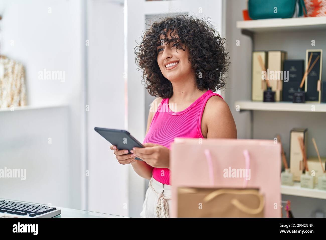Young middle eastern woman shop assistant using touchpad working at ...