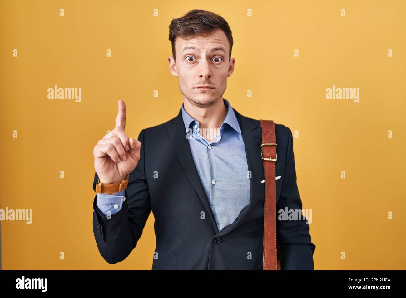Caucasian business man over yellow background pointing up looking sad ...
