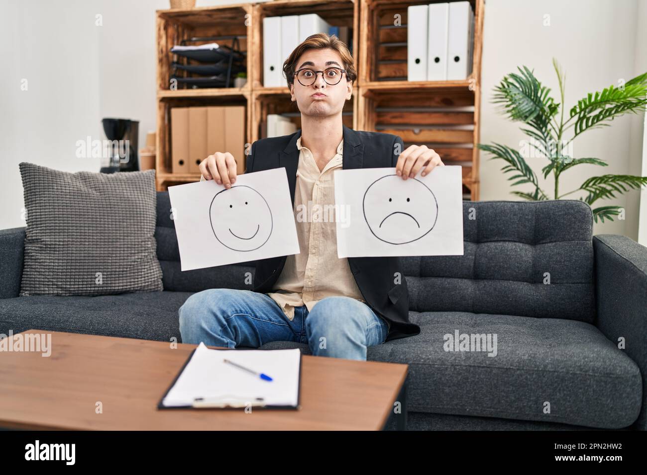 Young therapist man working on depression holding sad to happy emotion ...