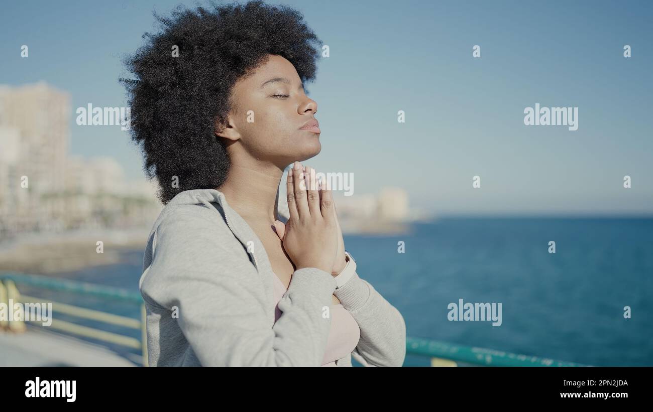 African american woman praying with closed eyes at seaside Stock Photo ...