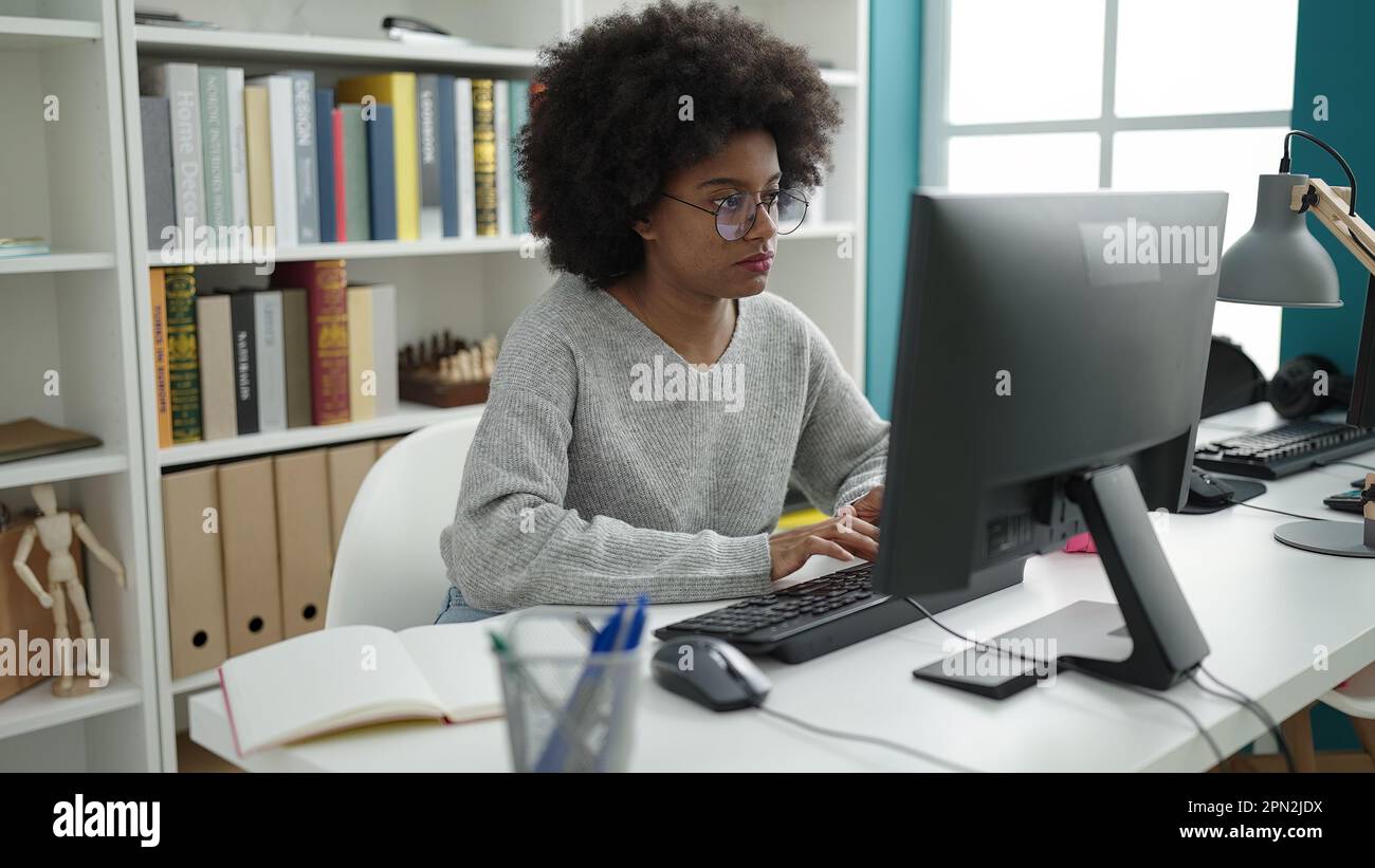 African american woman student using computer studying at library ...