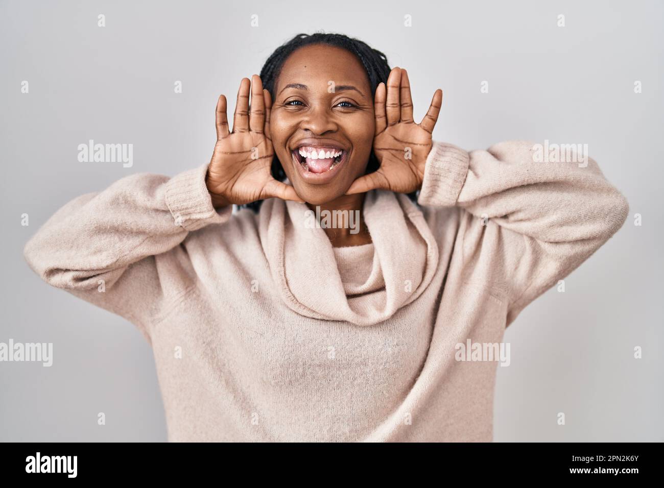 African woman standing over white background smiling cheerful playing ...