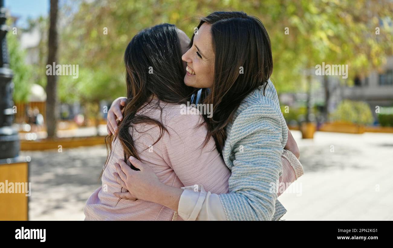 Two women hugging each other at park Stock Photo - Alamy