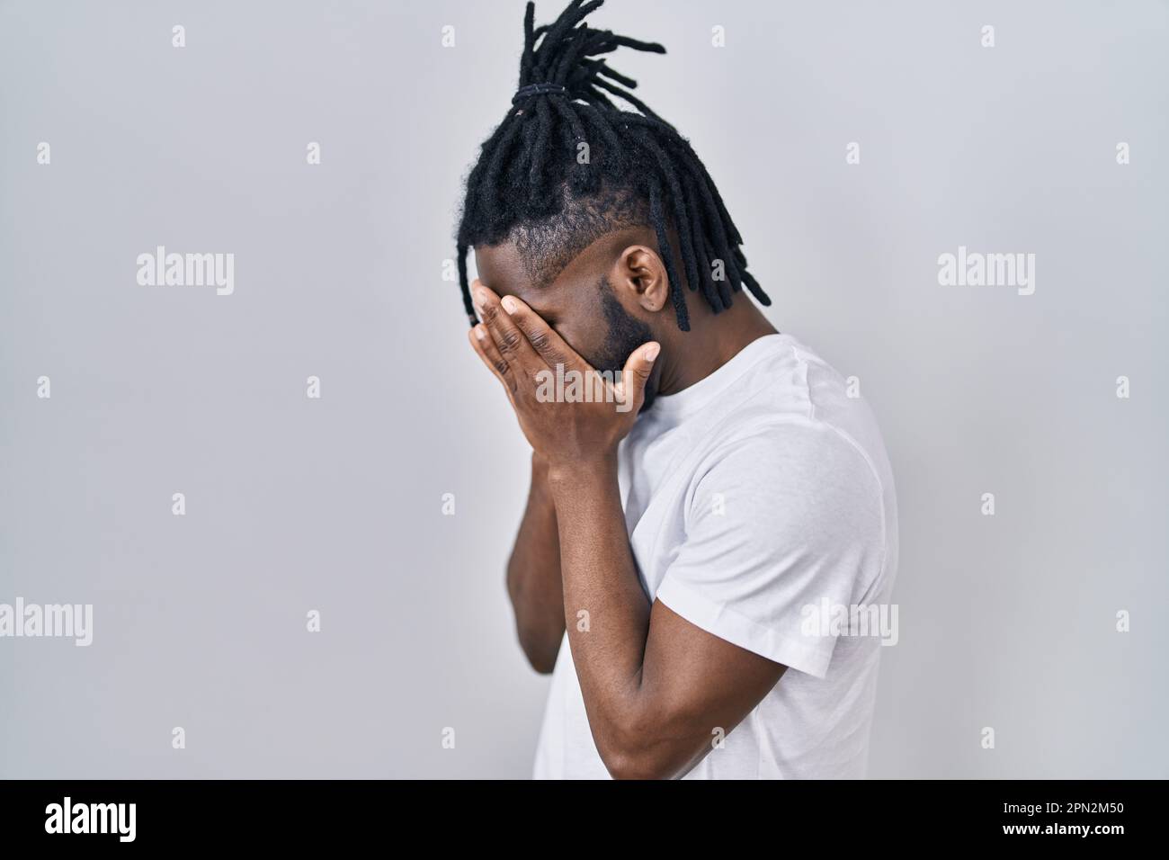 African man with dreadlocks wearing casual t shirt over white ...