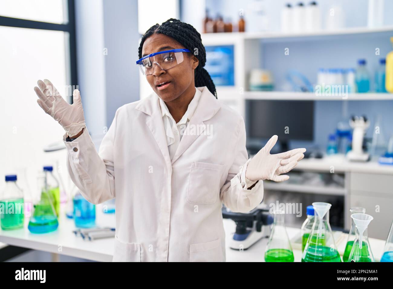 African american woman working at scientist laboratory shouting and ...