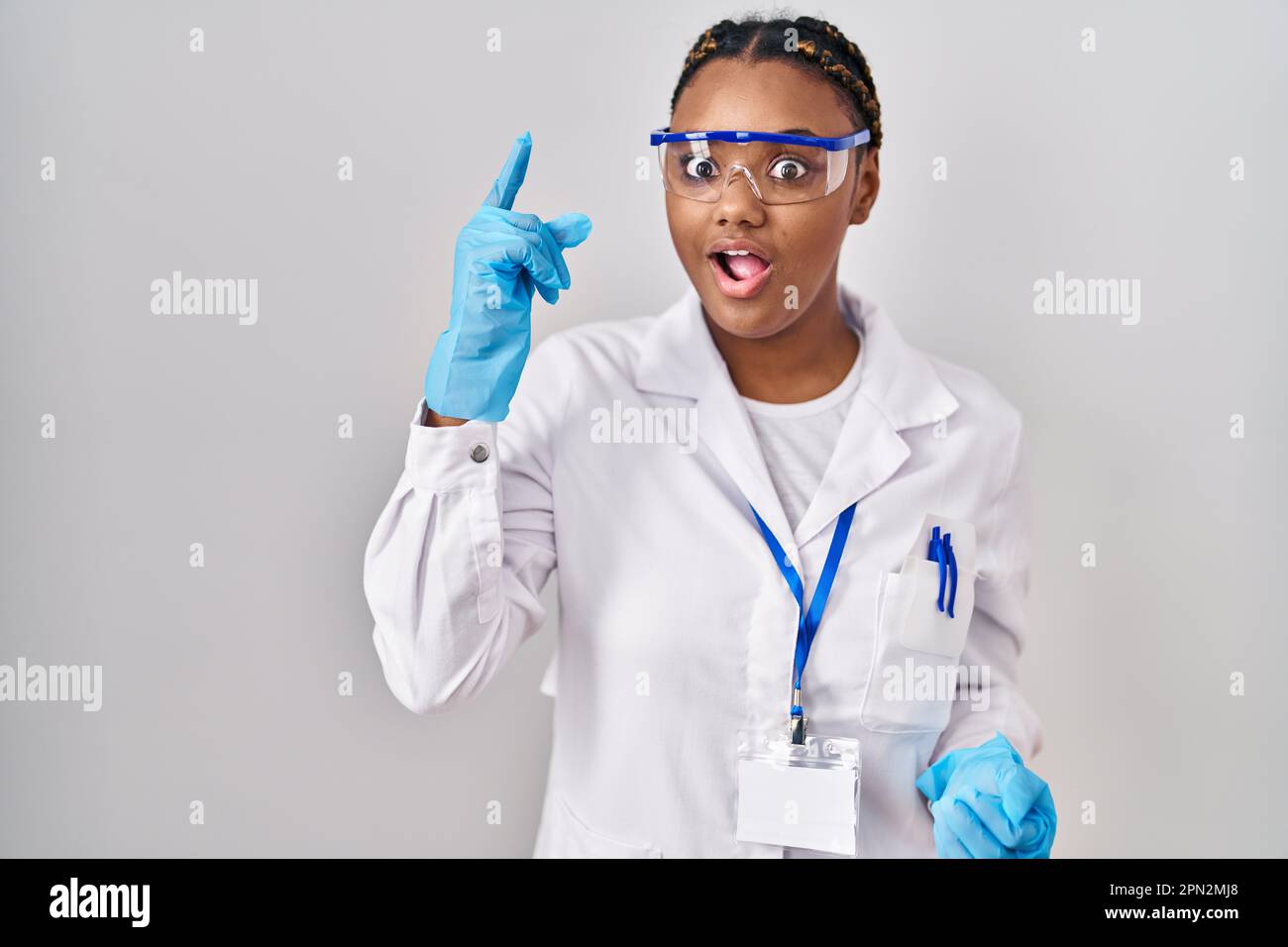 African american woman with braids wearing scientist robe pointing ...