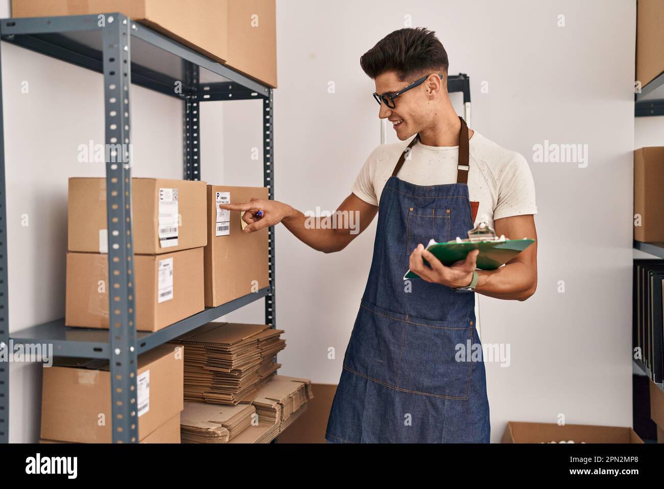 Young hispanic man ecommerce business worker organize packages at ...
