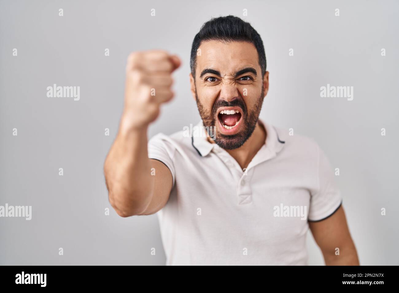 Young hispanic man with beard wearing casual clothes over white ...