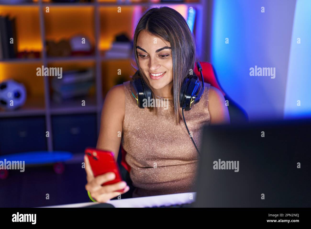 Young beautiful hispanic woman streamer using computer and smartphone ...