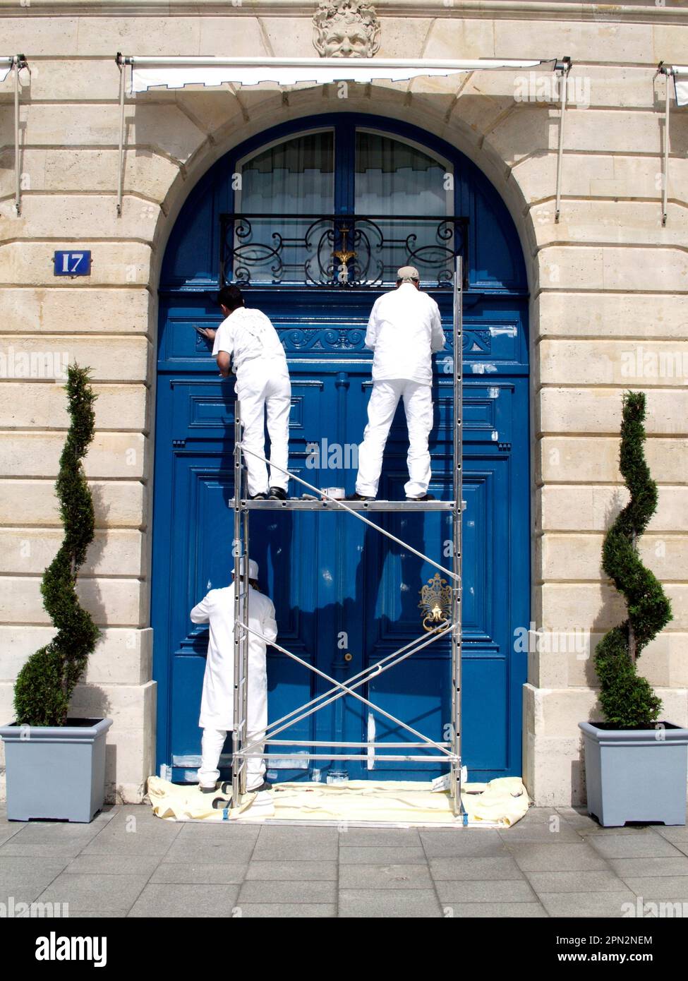 PAINTERS WORKING ON A LARGE DOOR OF A CLASSIC BUILDING IN PARIS FRANCE ...
