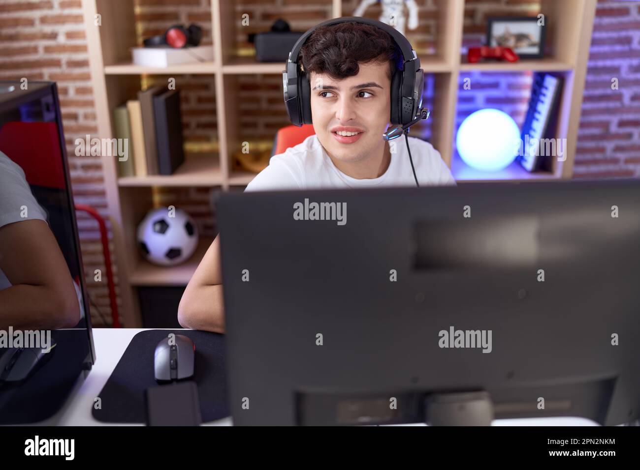 Non binary man streamer playing video game using computer at gaming room Stock Photo - Alamy