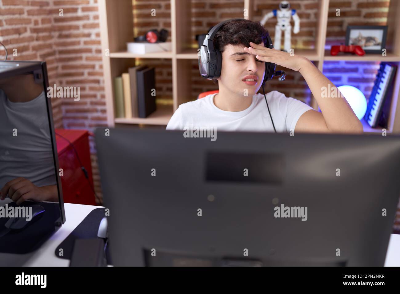 Non binary man streamer stressed using computer at gaming room Stock ...