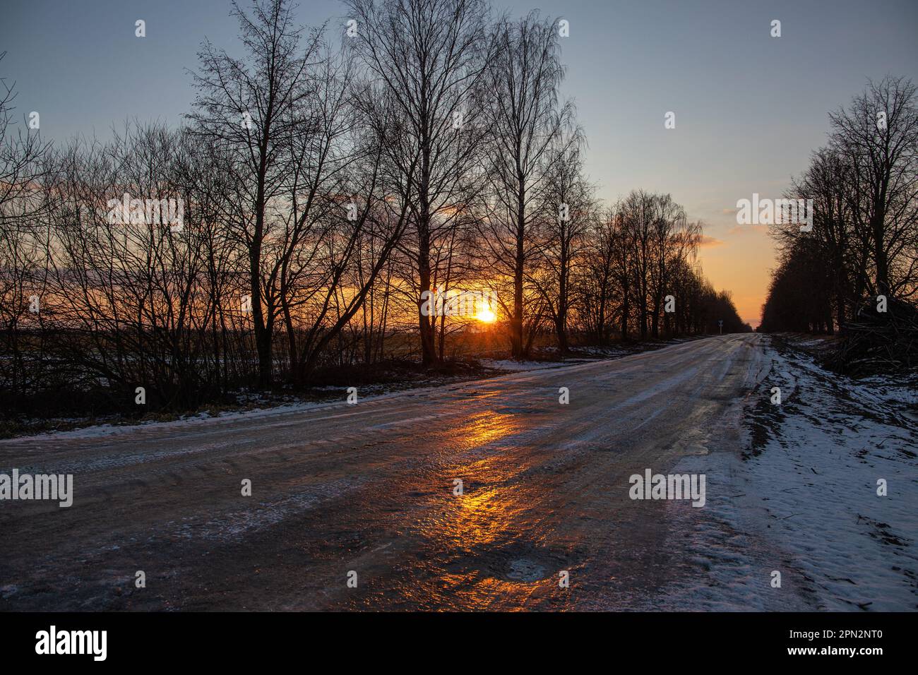 The winter road is illuminated by the sunset. The frozen nature of ...